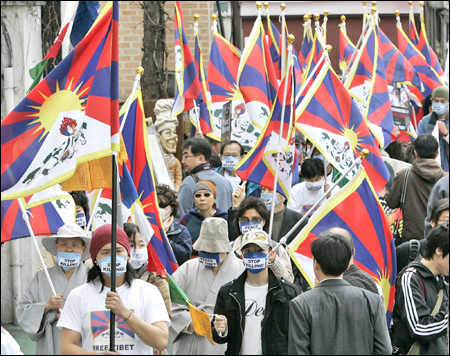 Anti-Chinese protesters hold Tibet flags as they march... - The Korea Times