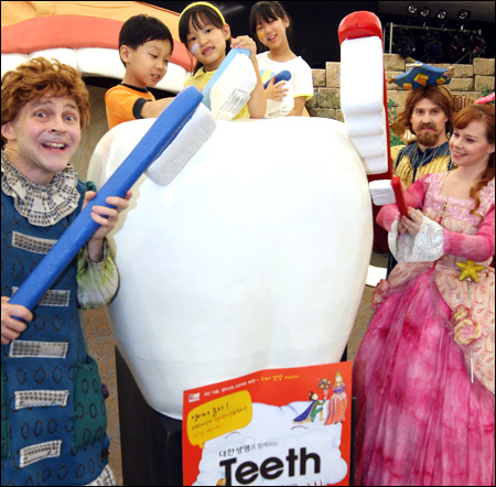 Children brush a large tooth with actors in the English ... - The Korea ...